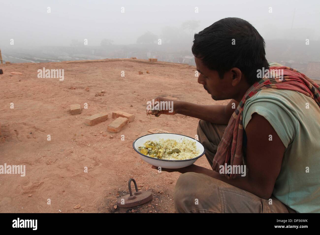 A laborer eats rice in brickfield at Savar, Dhaka 07 Jan 2014. Most of ...