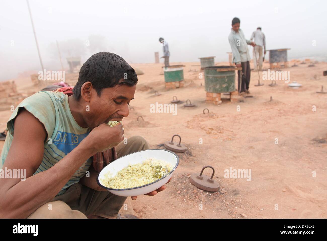 A laborer eats rice in brickfield at Savar, Dhaka 07 Jan 2014. Most of ...