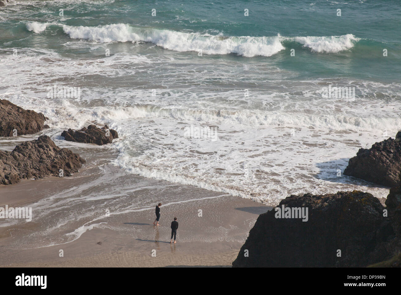 A couple on the beach at Kynance Cove, Lizard Point, Cornwall, England ...