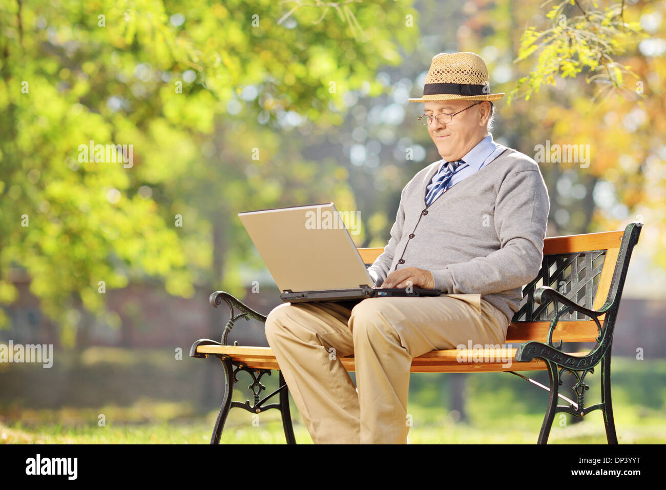 Man sitting on a park bench with a laptop hi-res stock photography and ...