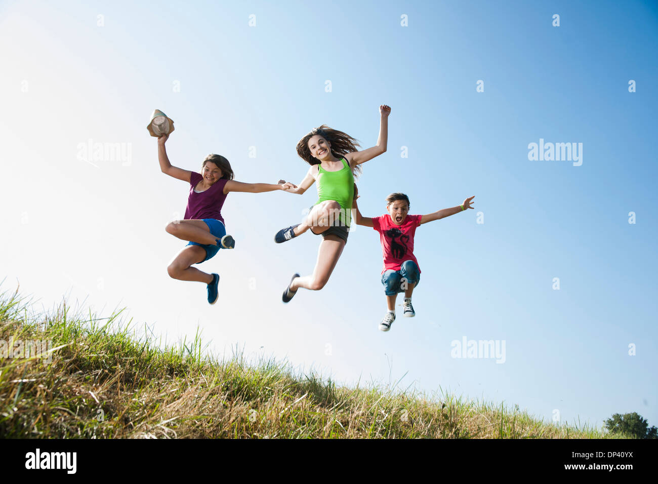 Girls jumping in mid-air over field, Germany Stock Photo - Alamy