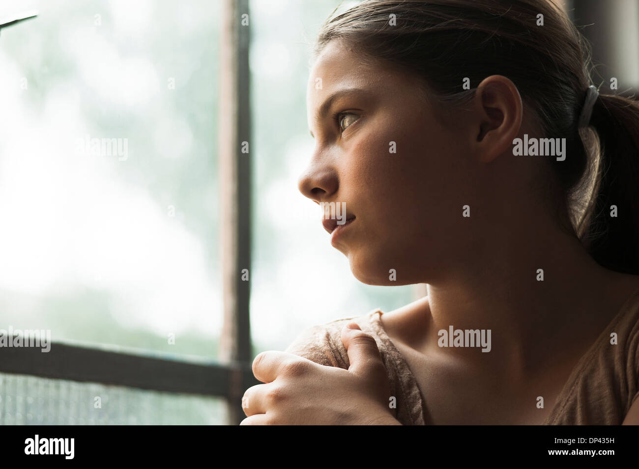 Girl looking out of window, Germany Stock Photo - Alamy