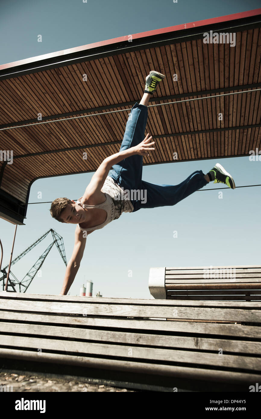 Teenaged boy doing handstand on barrier, freerunning, Germany Stock ...