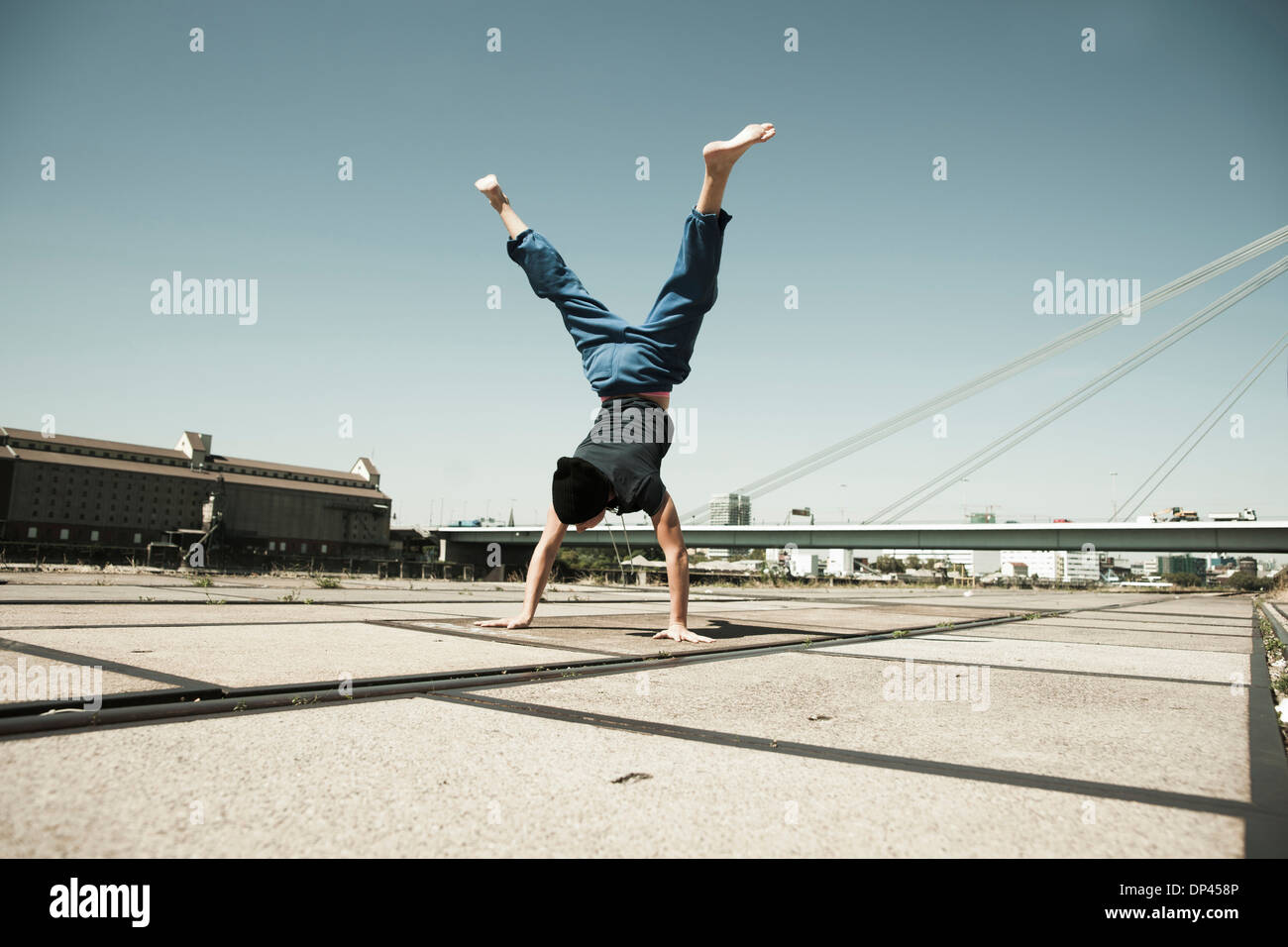 Teenaged boy doing handstand on cement road, freerunning, Germany Stock ...