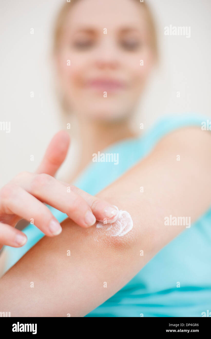 Woman applying body lotion Stock Photo - Alamy