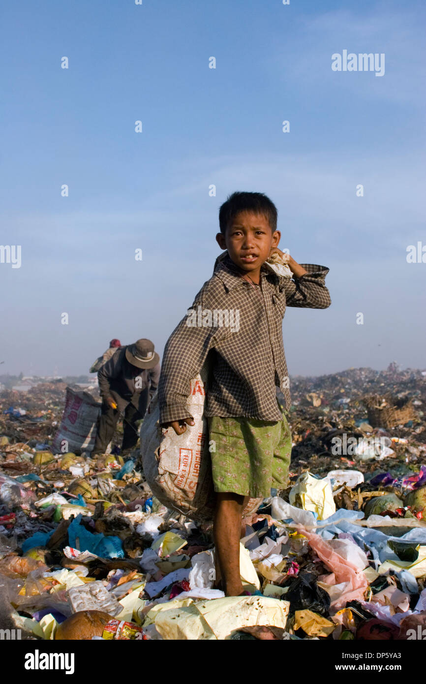 A young child laborer boy is collecting recyclable material at the ...