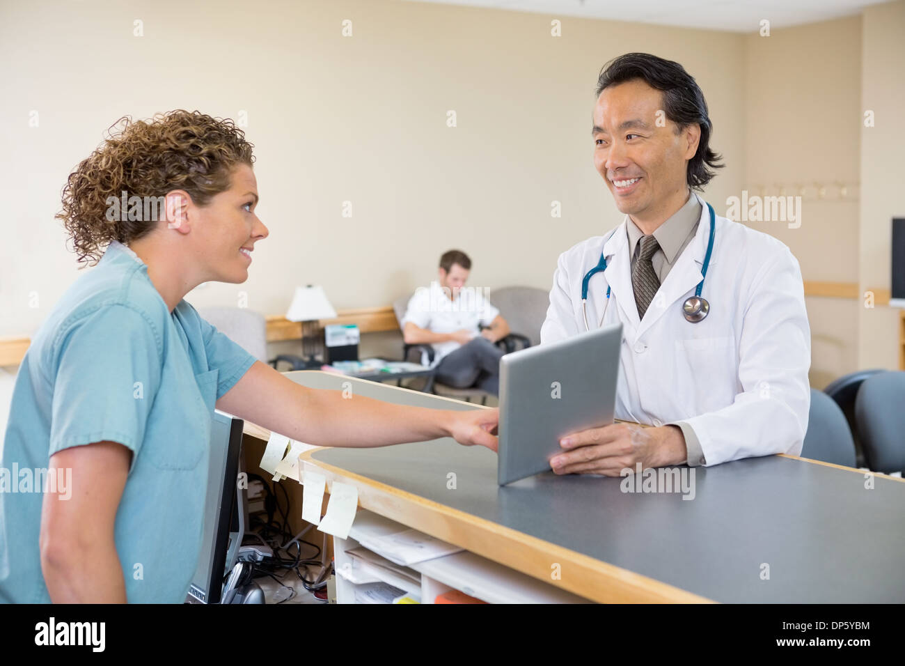 Doctor And Nurse Using Digital Tablet At Hospital Reception Stock Photo ...