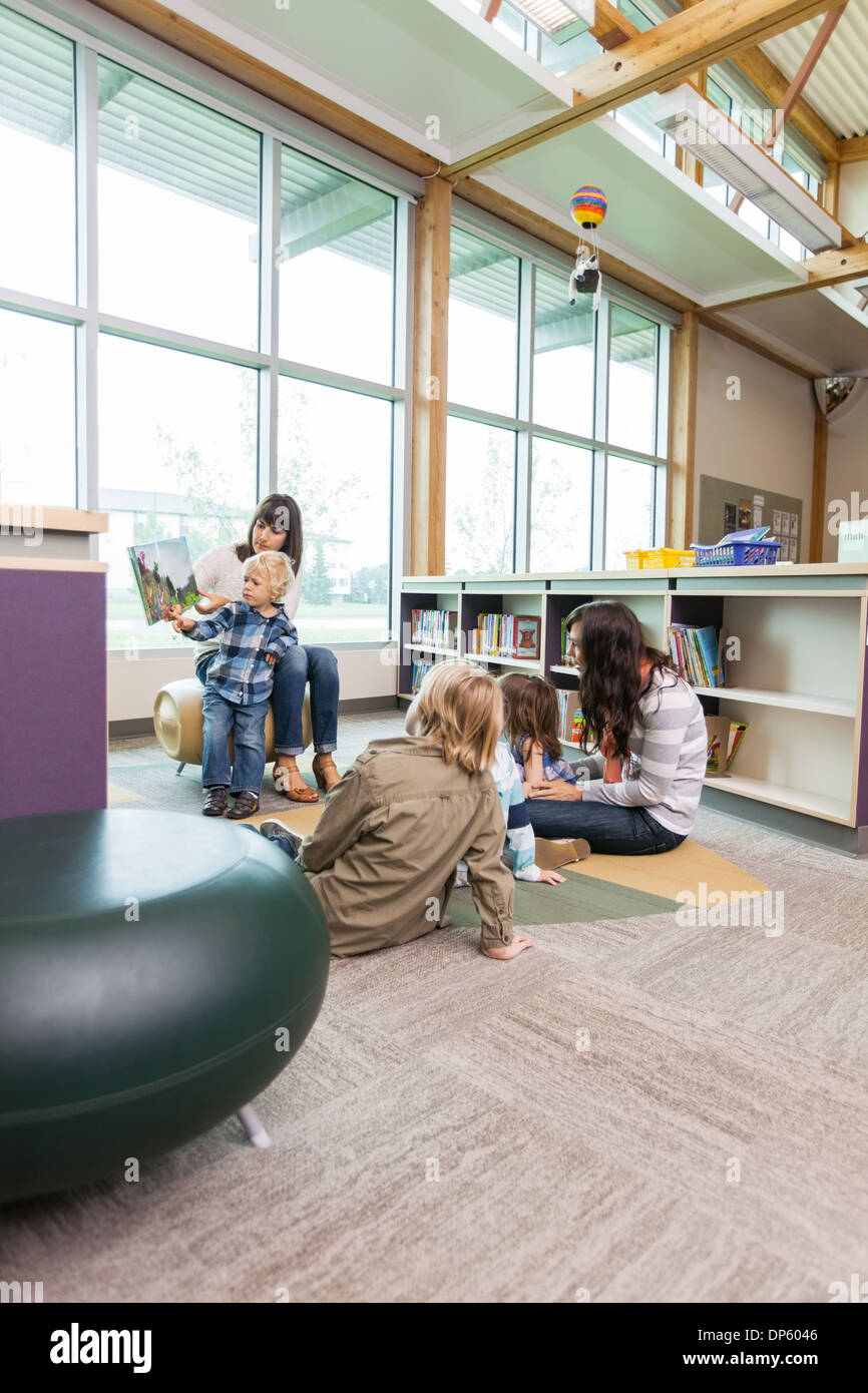 Teachers And Primary Students In Library Stock Photo - Alamy