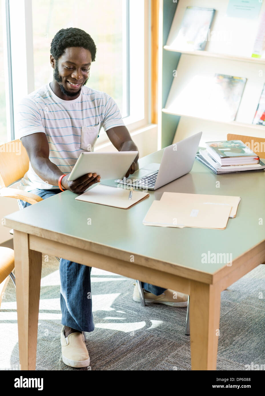 Student Using Technologies While Studying In Library Stock Photo - Alamy