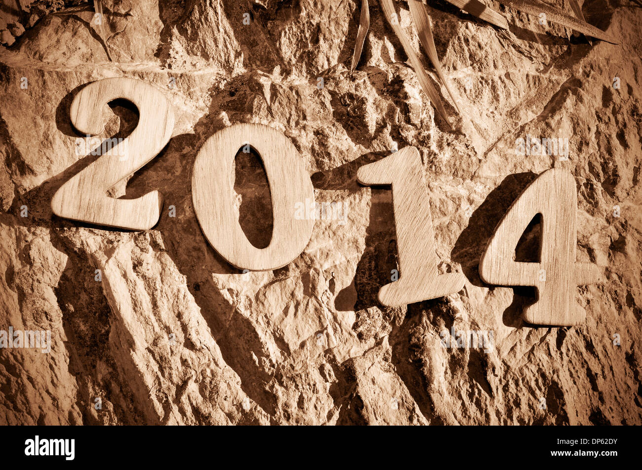 wooden numbers forming 2014, as the new year, on an irregular stone ...