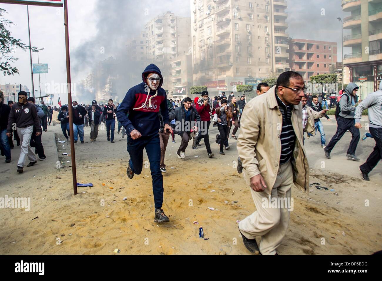 Cairo, Egypt. 8th Jan, 2014. Protesters escape tear gas fired by riot ...