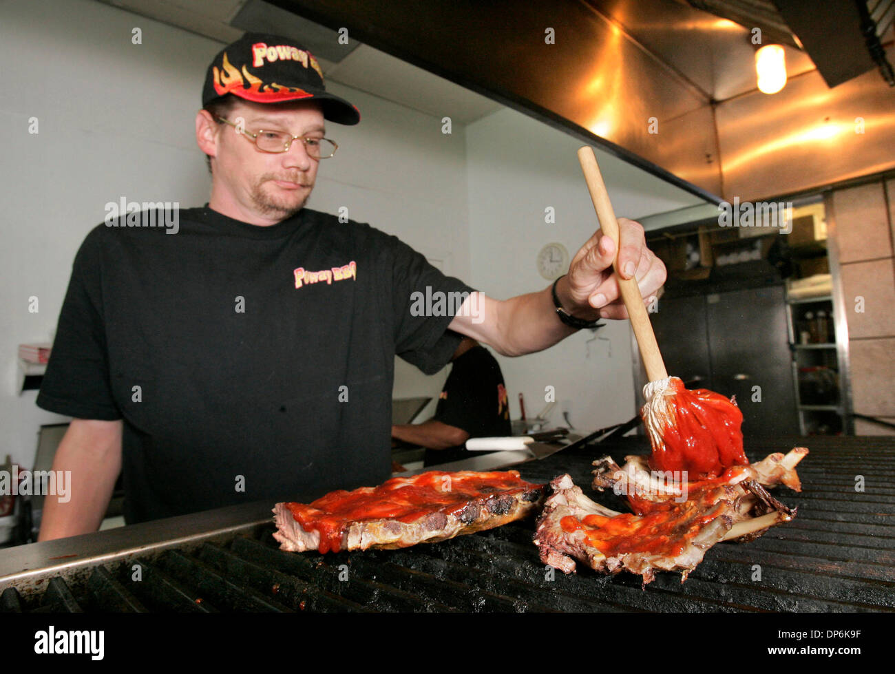 Oct 18, 2006; Poway, CA, USA; Owner/cook JOE GOODINE applies barbecue ...