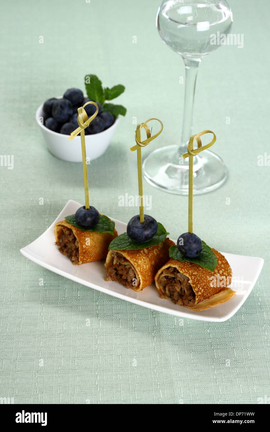 Pancake roll stuffed with minced meat on green background as snack ...