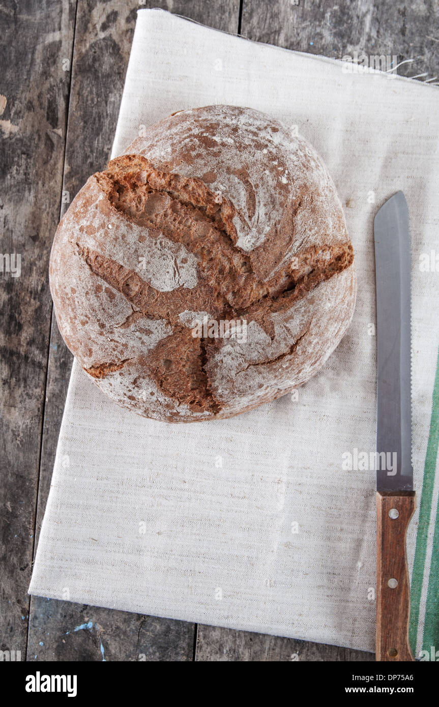 Homemade bread and knife on wooden table Stock Photo - Alamy