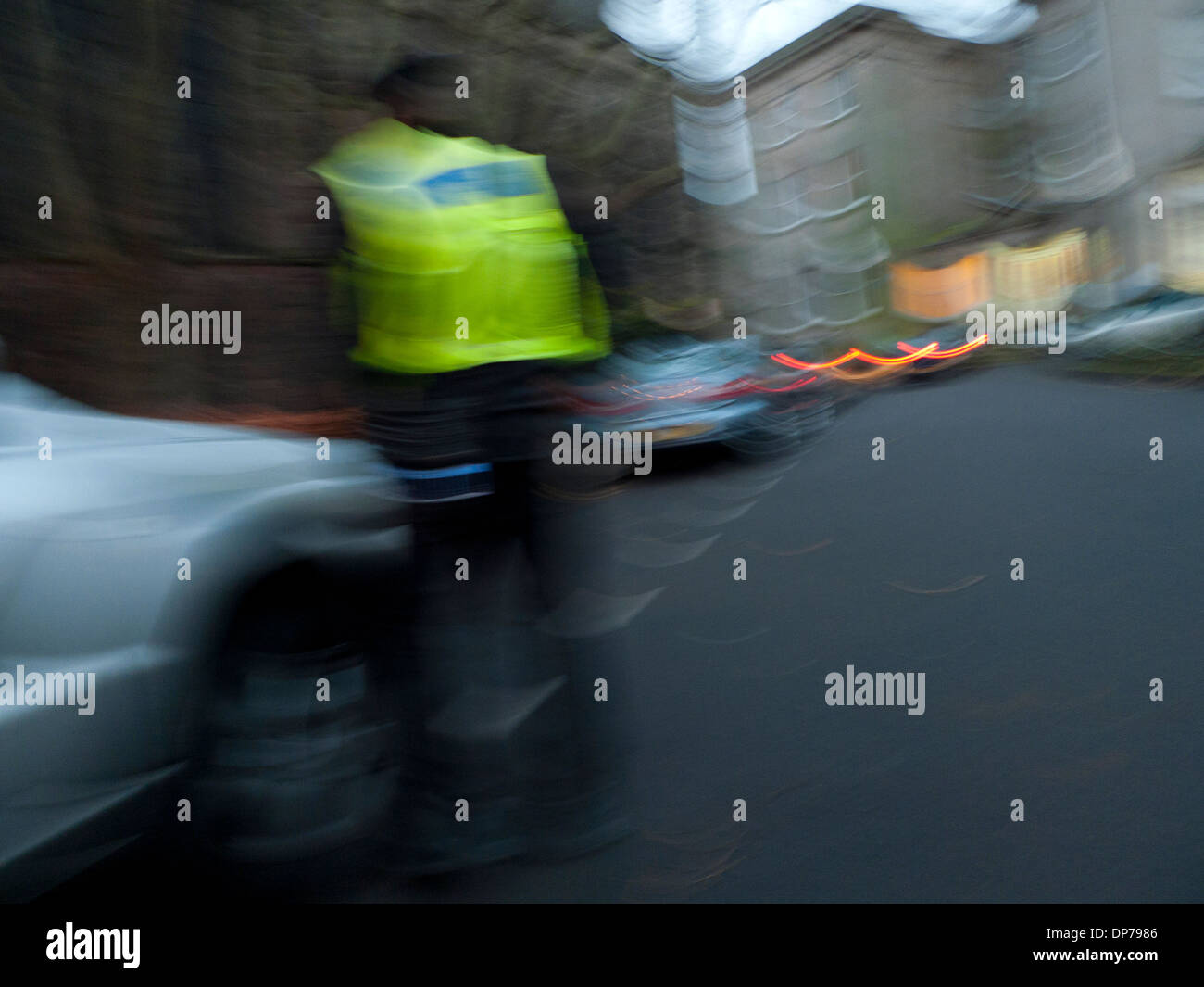 A traffic warden placing a parking fine penalty onto the windscreen of ...