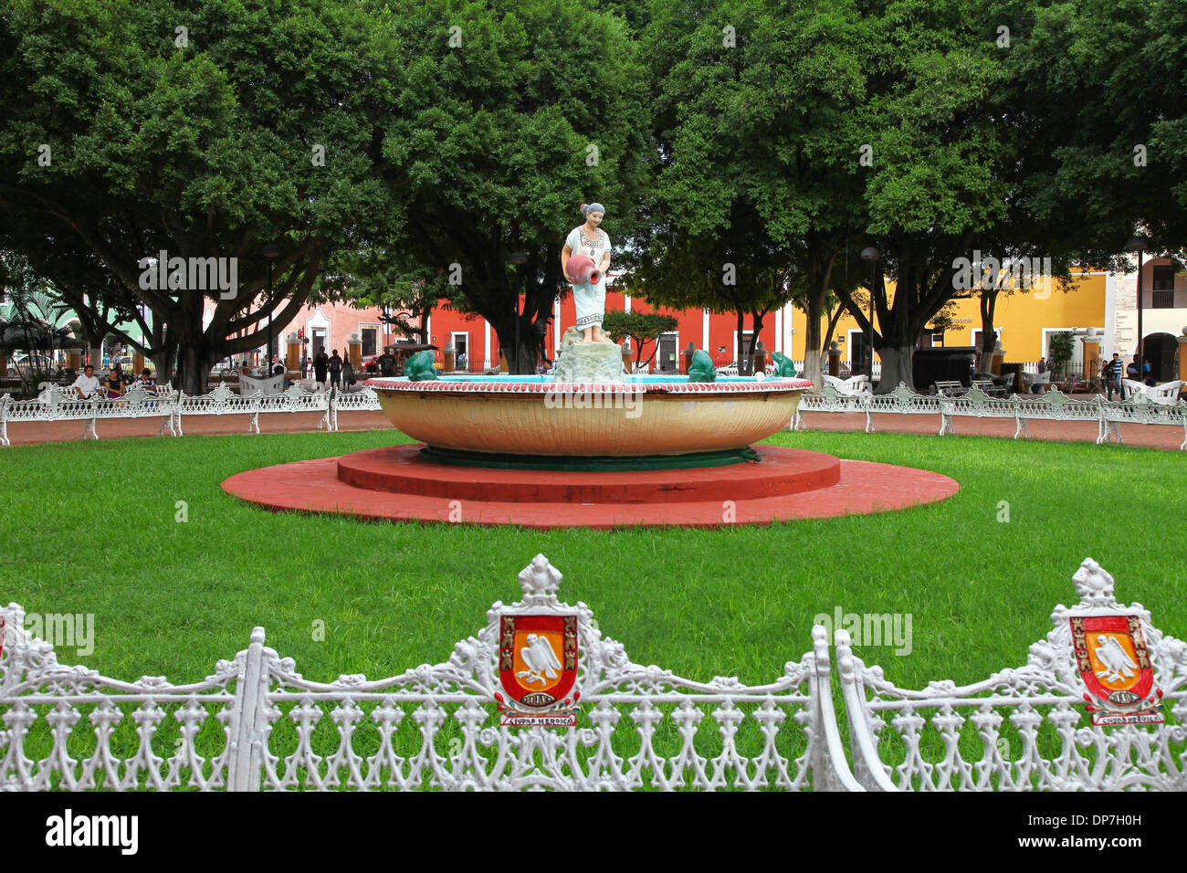 A statue of a woman and a pitcher in a fountain in the park at ...