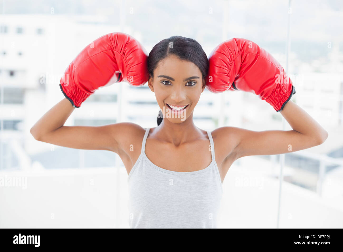 Smiling competitive model wearing red boxing gloves Stock Photo - Alamy