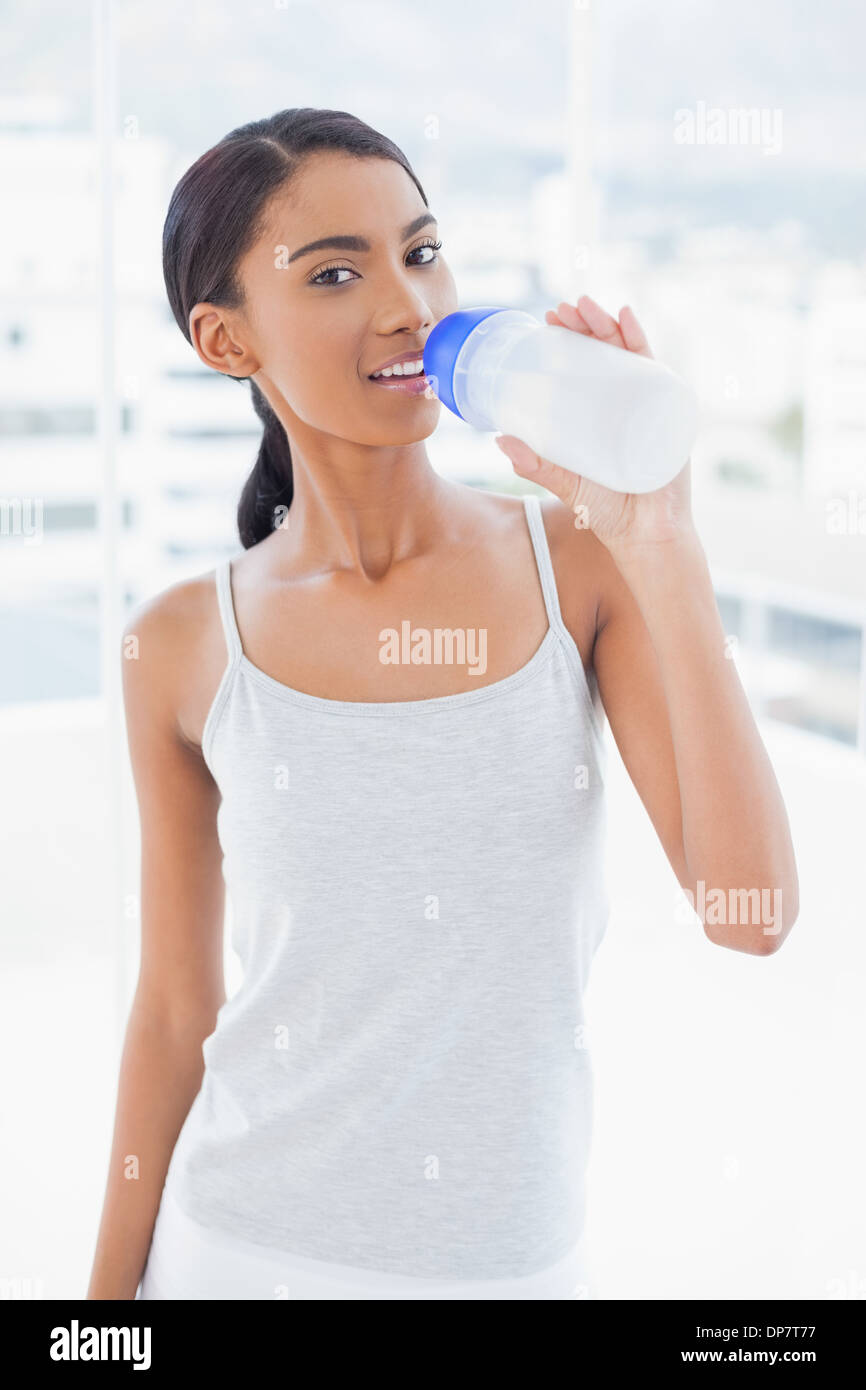 Smiling sporty model drinking water from her flask Stock Photo - Alamy