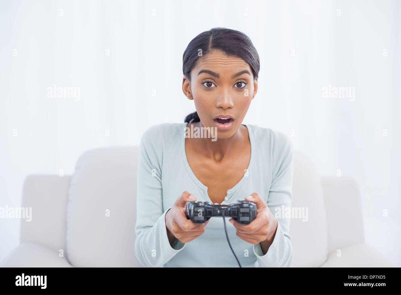 Shocked woman sitting on sofa playing video games Stock Photo - Alamy
