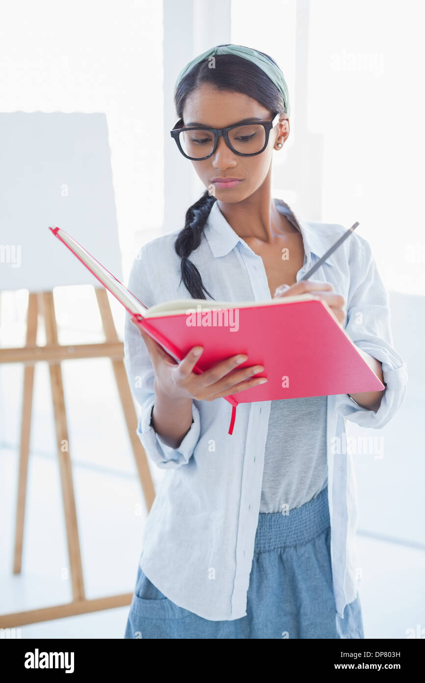 Concentrated attractive artist drawing on her notebook Stock Photo - Alamy
