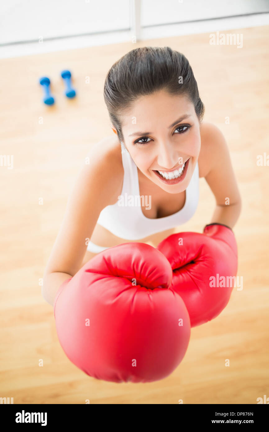 Fit woman wearing red boxing gloves smiling at camera Stock Photo - Alamy