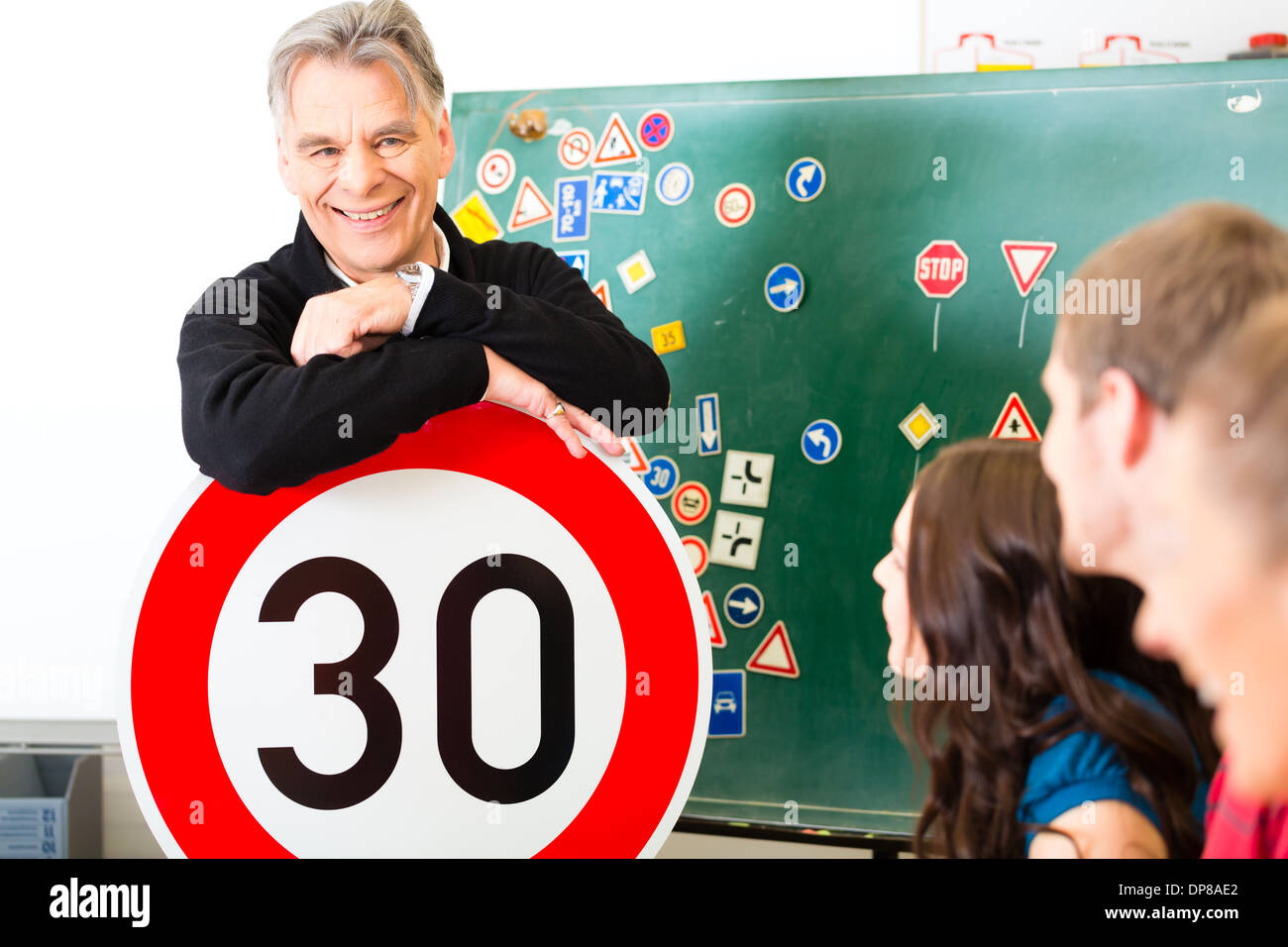 Driving school - driving instructor and student drivers look at a tempo ...