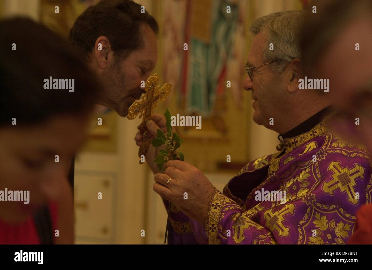 (Published 5/26/2005, E-1) A man kisses a cross held by Father Theodore ...