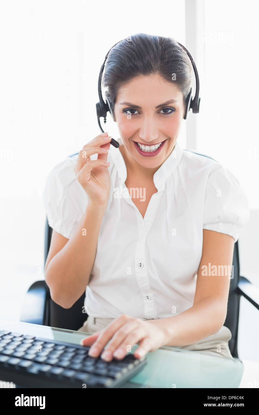 Smiling call centre agent working at her desk on a call Stock Photo - Alamy