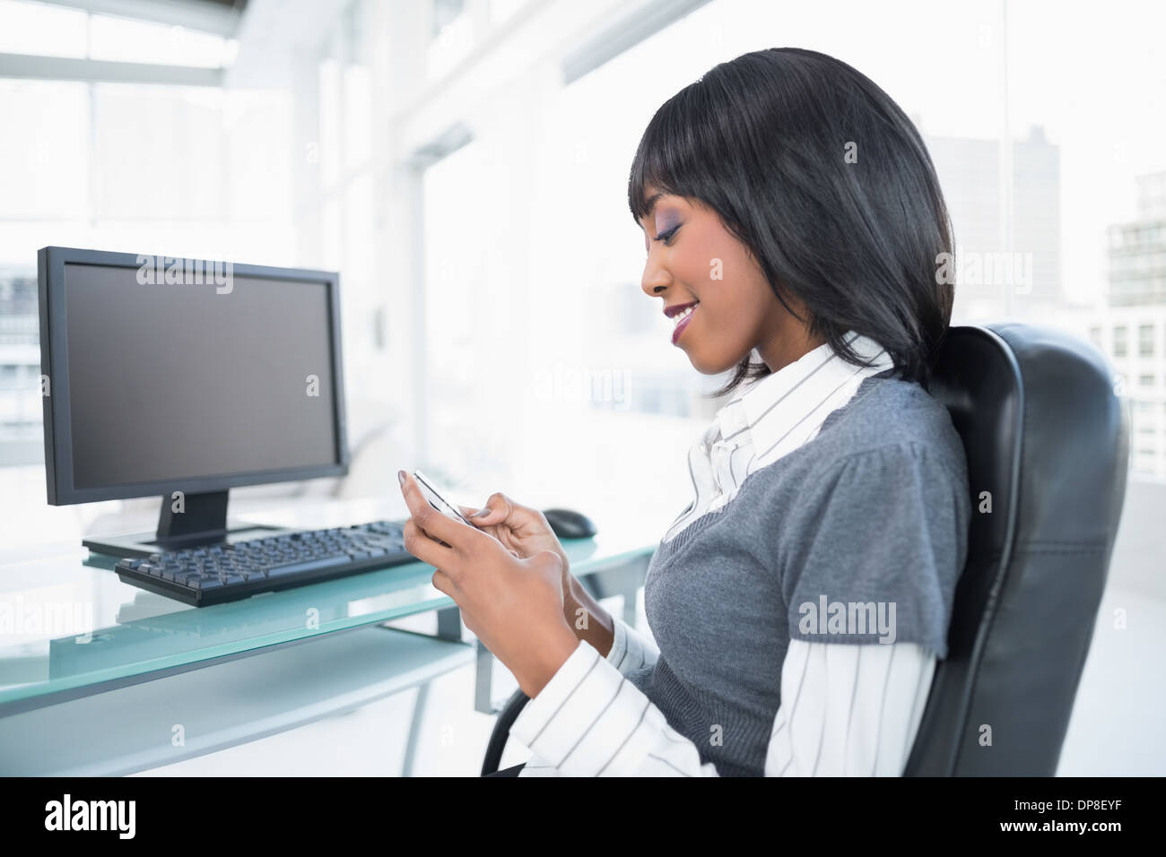Smiling businesswoman texting Stock Photo - Alamy