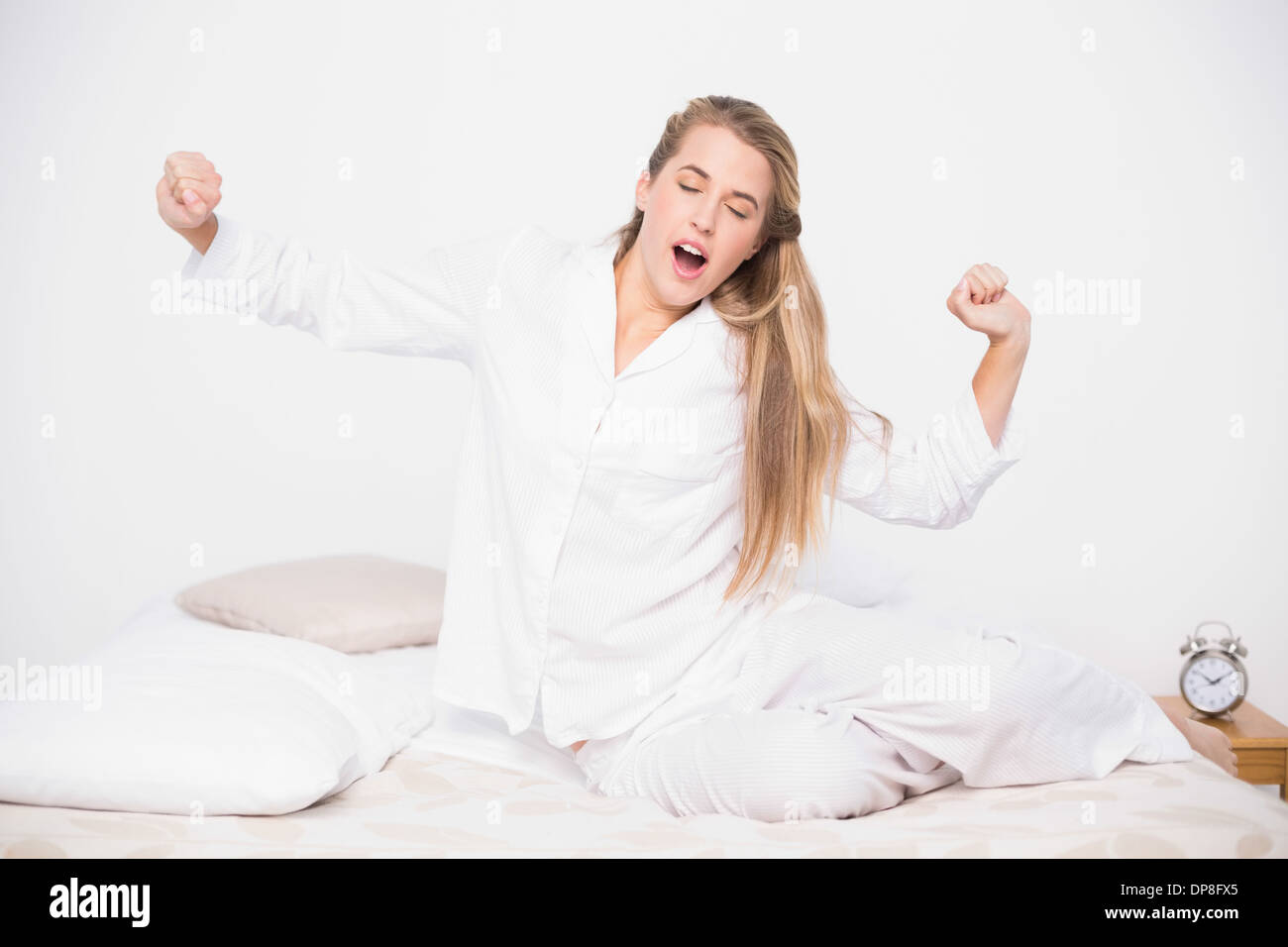 Yawning pretty model stretching in cosy bed Stock Photo - Alamy