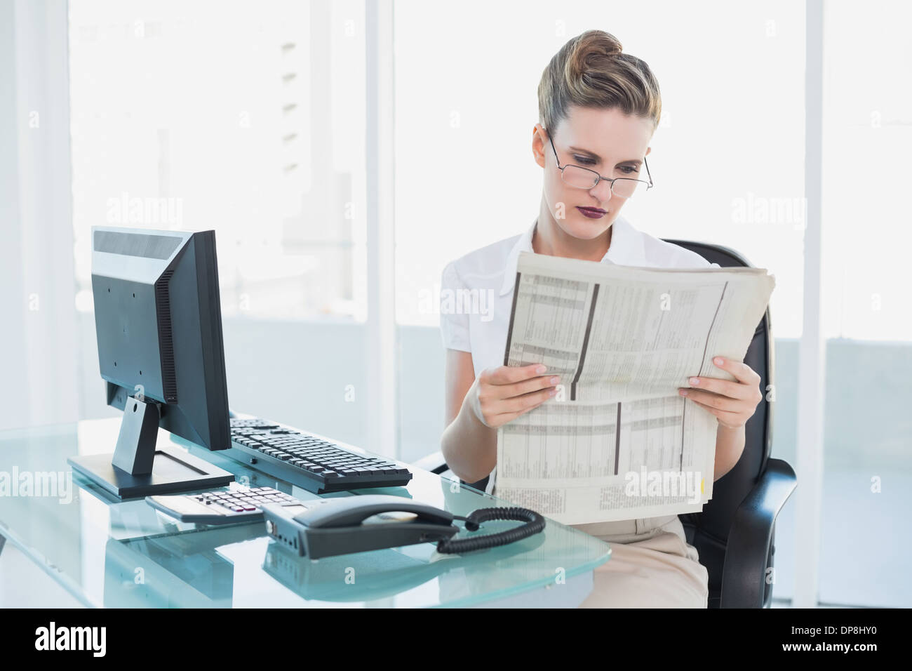 Serious businesswoman reading newspaper Stock Photo - Alamy