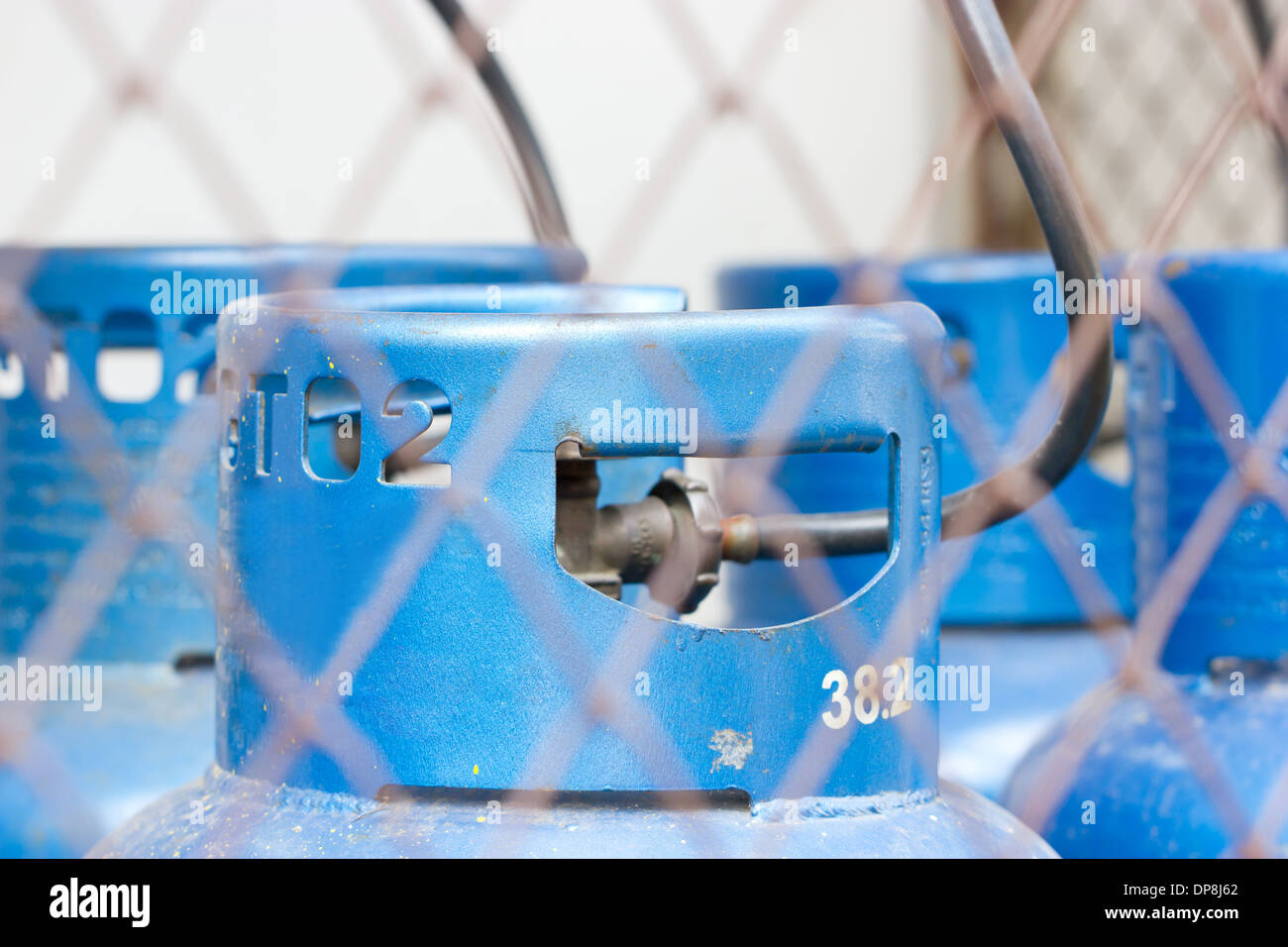 Gas tank behind wire fence focusing at the tank Stock Photo - Alamy