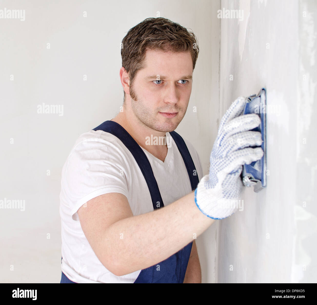 Male plasterer polishing the wall Stock Photo - Alamy