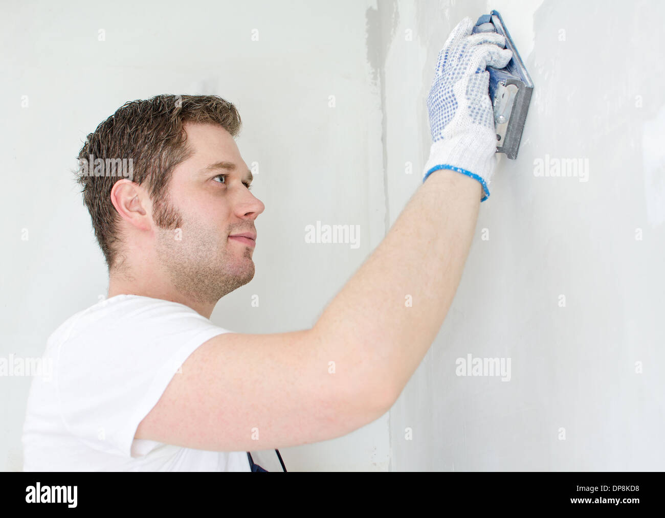 Male plasterer polishing the wall Stock Photo - Alamy