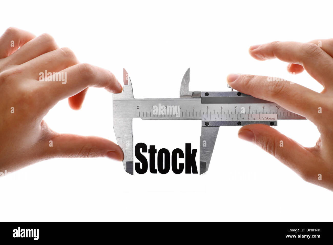 Two hands holding a caliper, measuring the word "Stock Stock Photo - Alamy