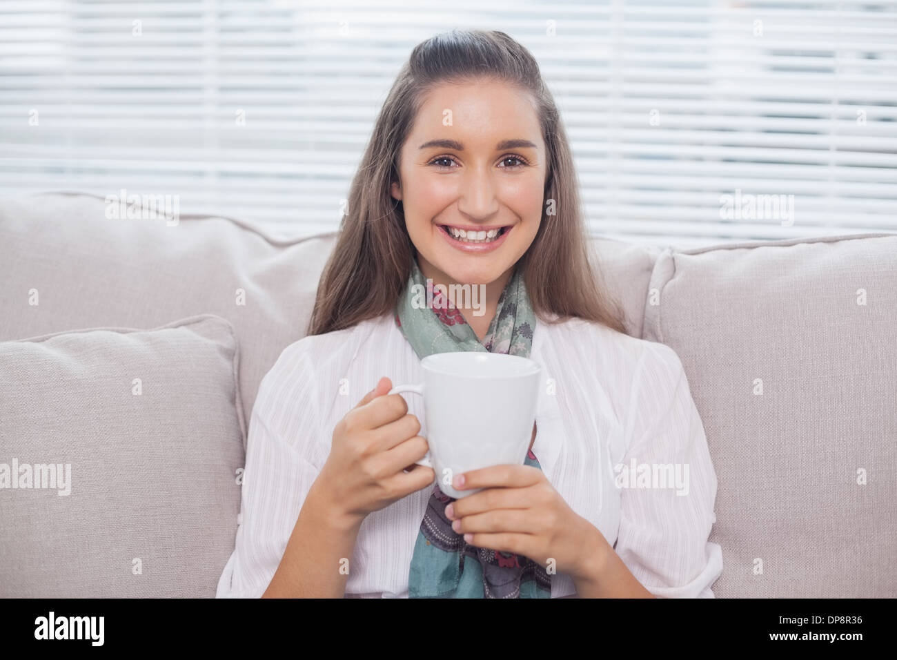 Cheerful pretty model holding cup of coffee Stock Photo - Alamy