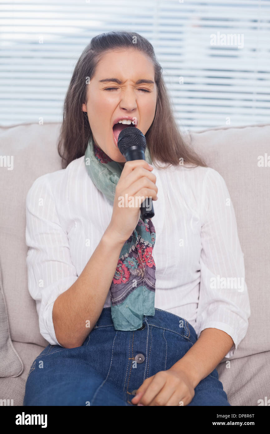Gorgeous model singing on microphone Stock Photo - Alamy