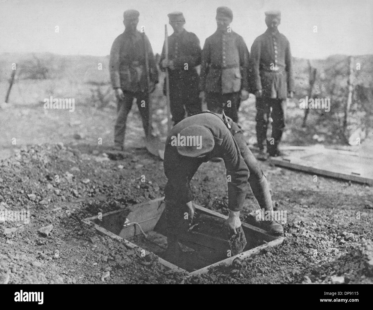 A German soldier positions a big demolition charge in a box-type mine ...