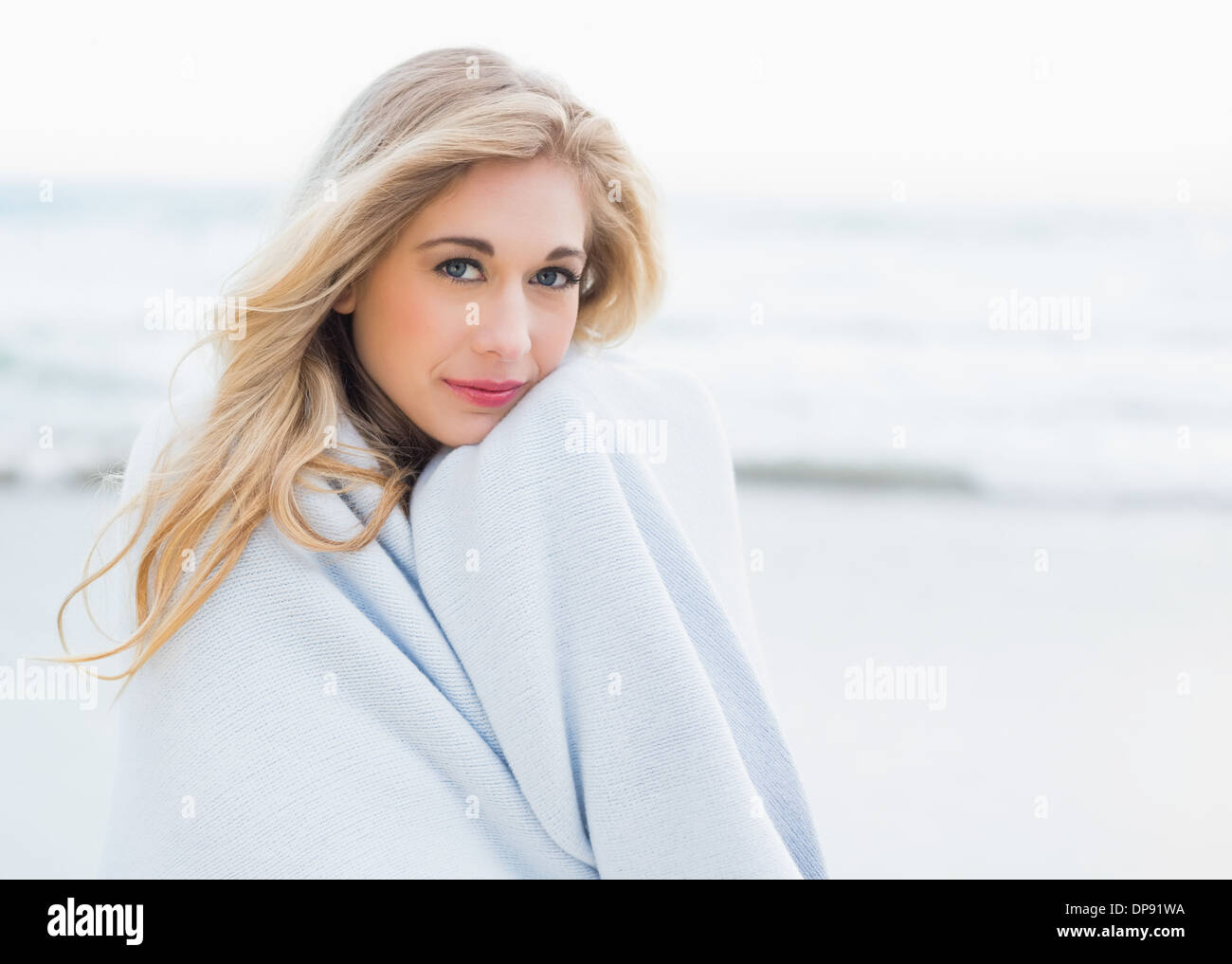 Calm blonde woman warming herself in a blanket Stock Photo - Alamy