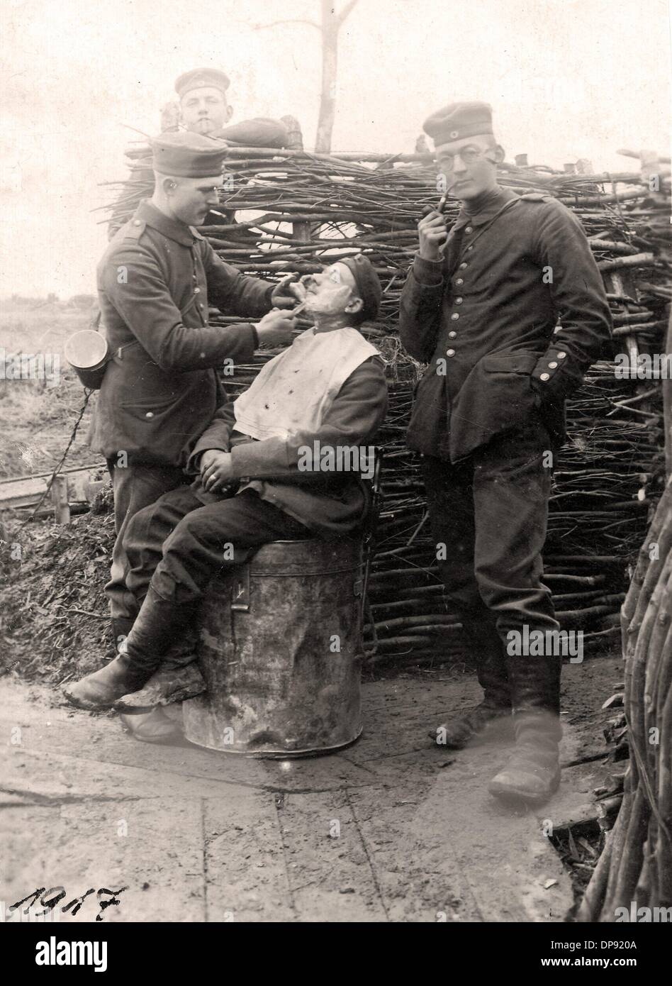 A field postcard depicts a German soldier getting a shave in a trench ...