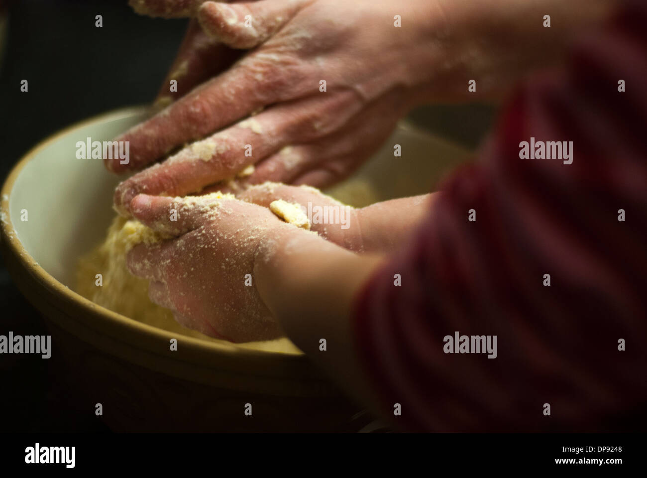 Woman with childs hands crumbling mixture in a mixing bowl Stock Photo ...