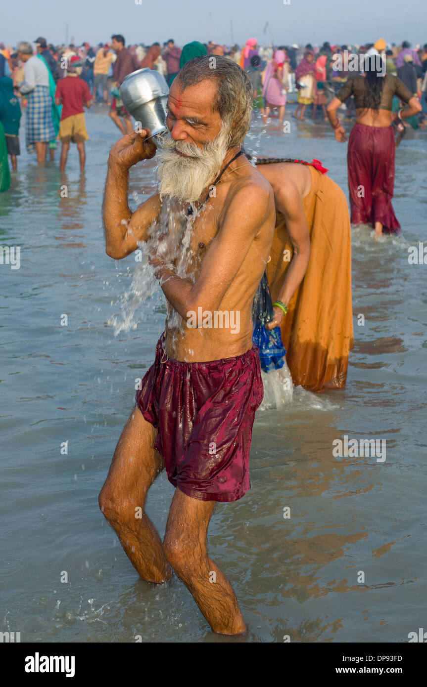 Elderly male pilgrim with a white beard bathing in the Bay of Bengal at ...
