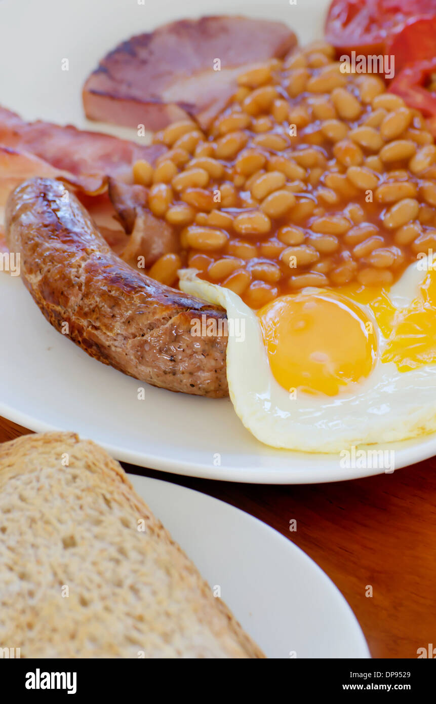 Traditional English breakfast - egg, beans , toast, sausage and bacon ...