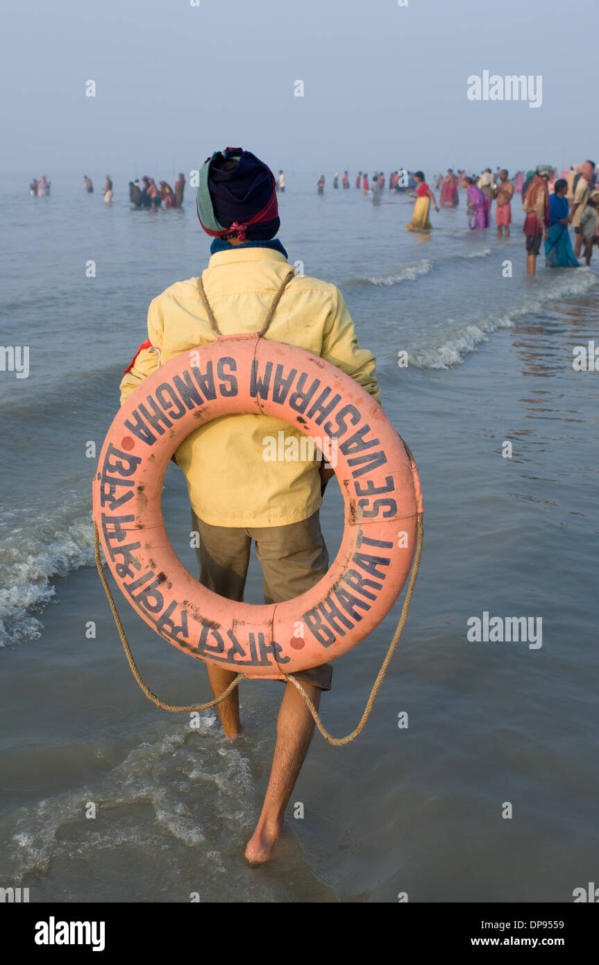 Life guard carrying a lifebuoy on the shores of the Bay of Bengal at ...