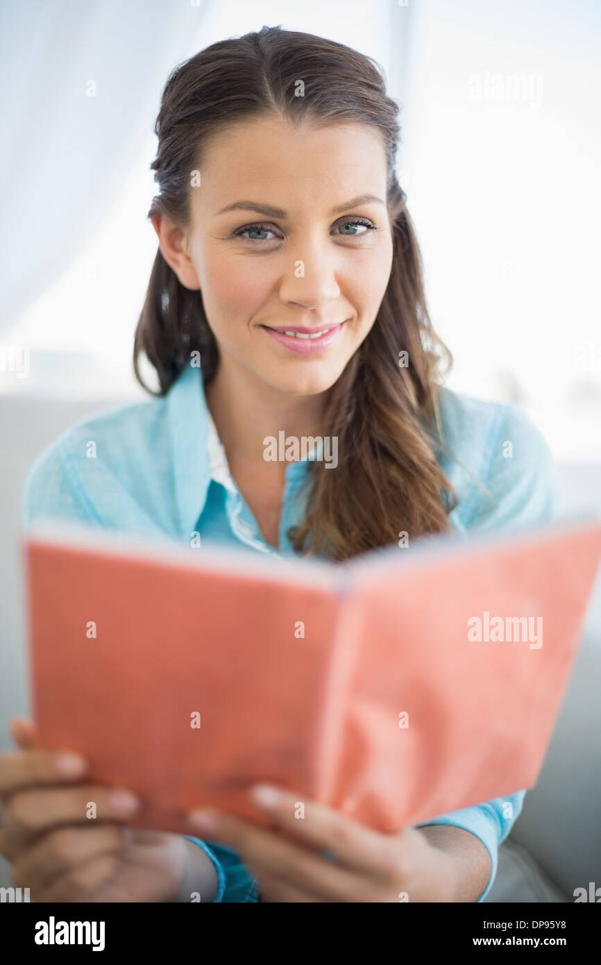 Peaceful woman sitting on sofa reading book Stock Photo - Alamy