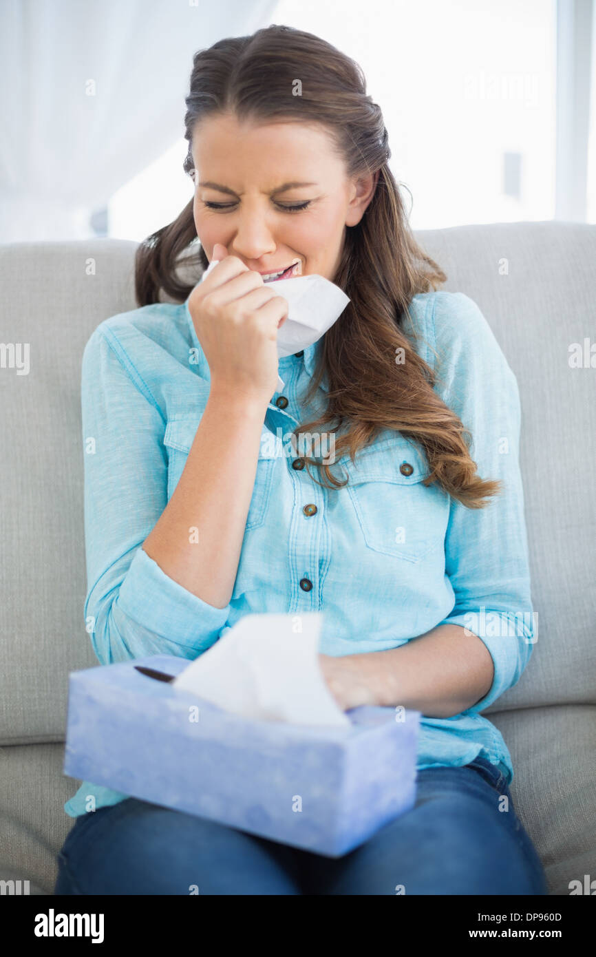 Woman crying sitting on sofa Stock Photo - Alamy