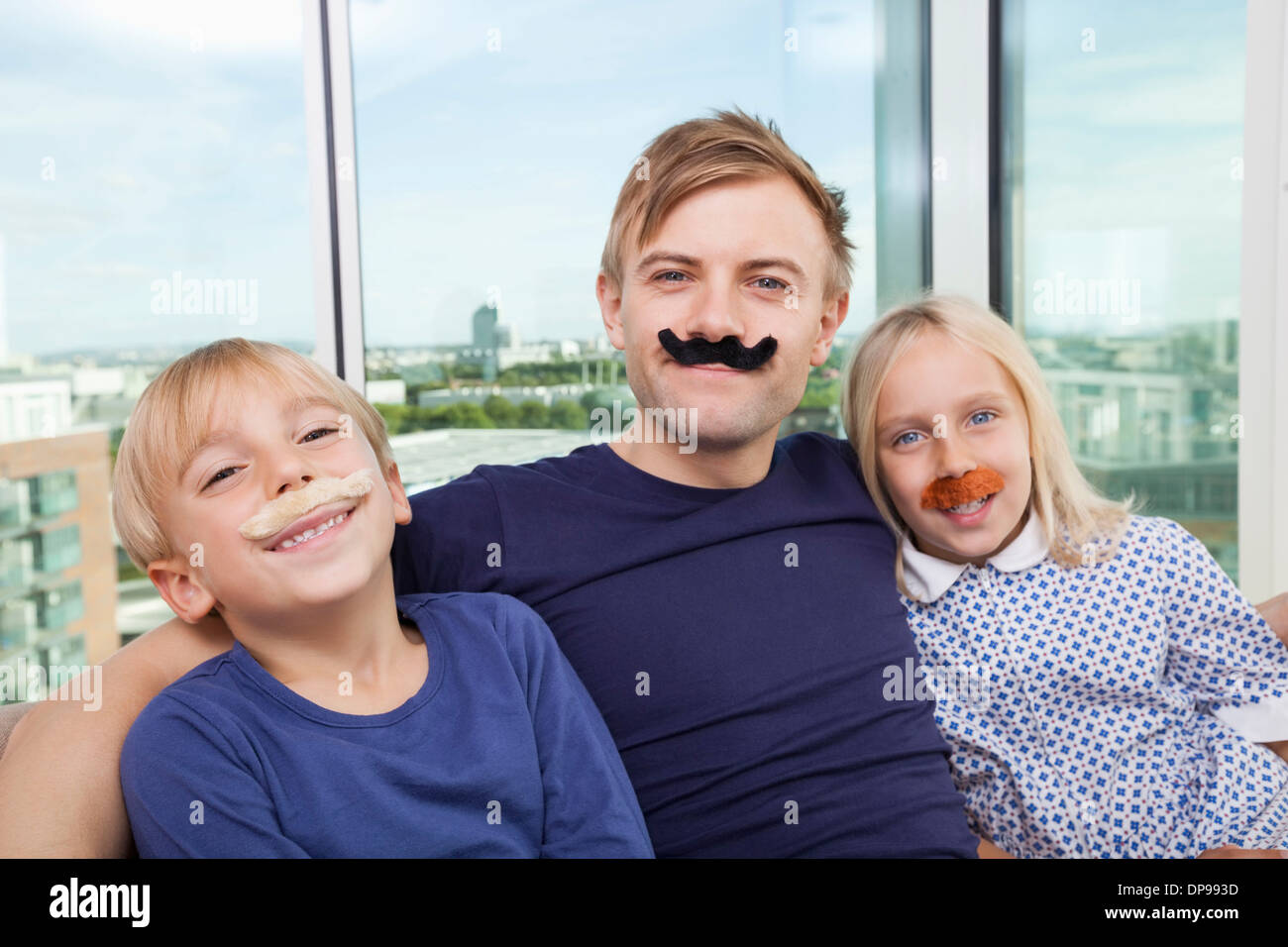 Portrait of father and children with artificial mustache at home Stock ...