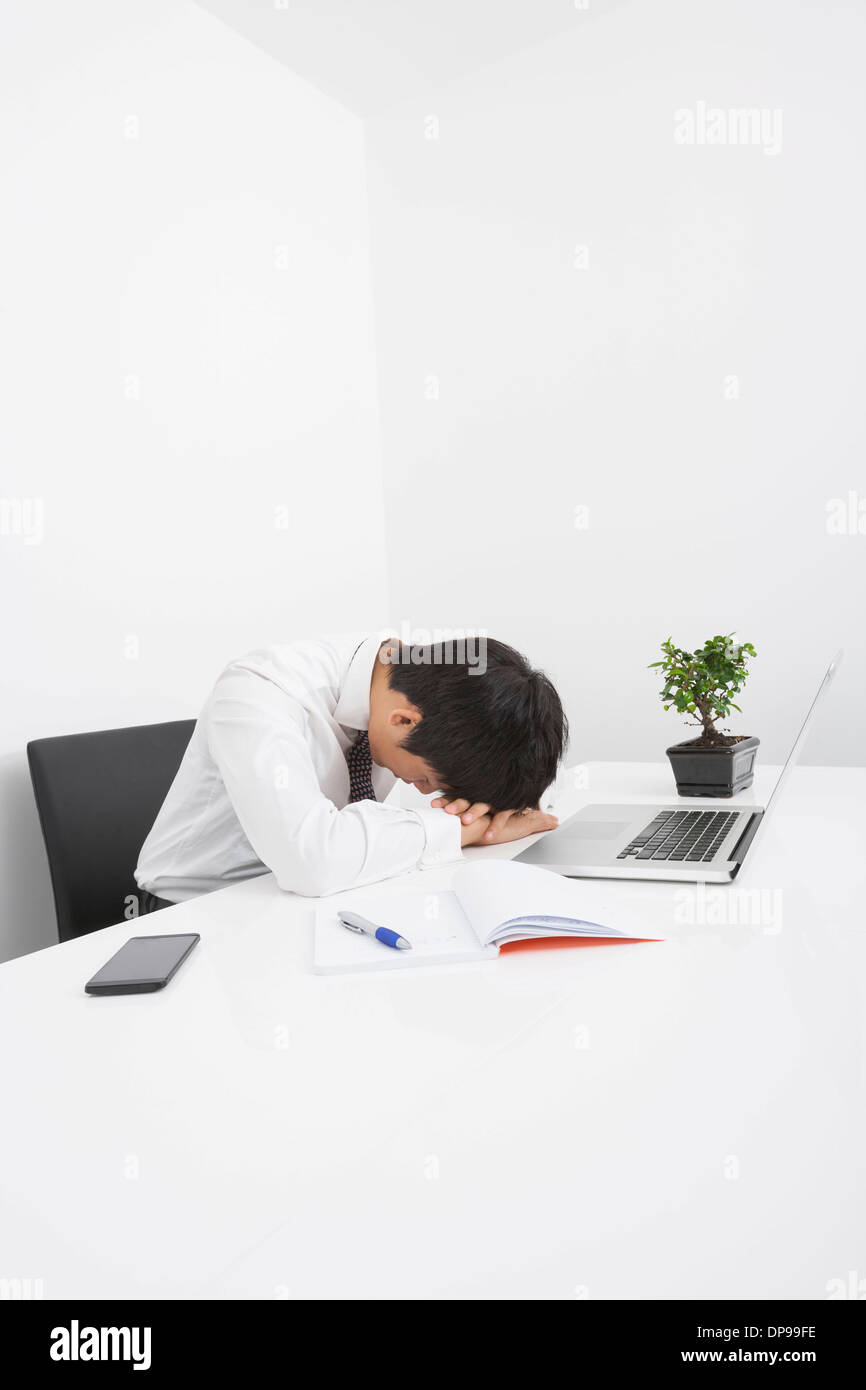 Tired mid adult businessman sleeping on desk in office Stock Photo - Alamy