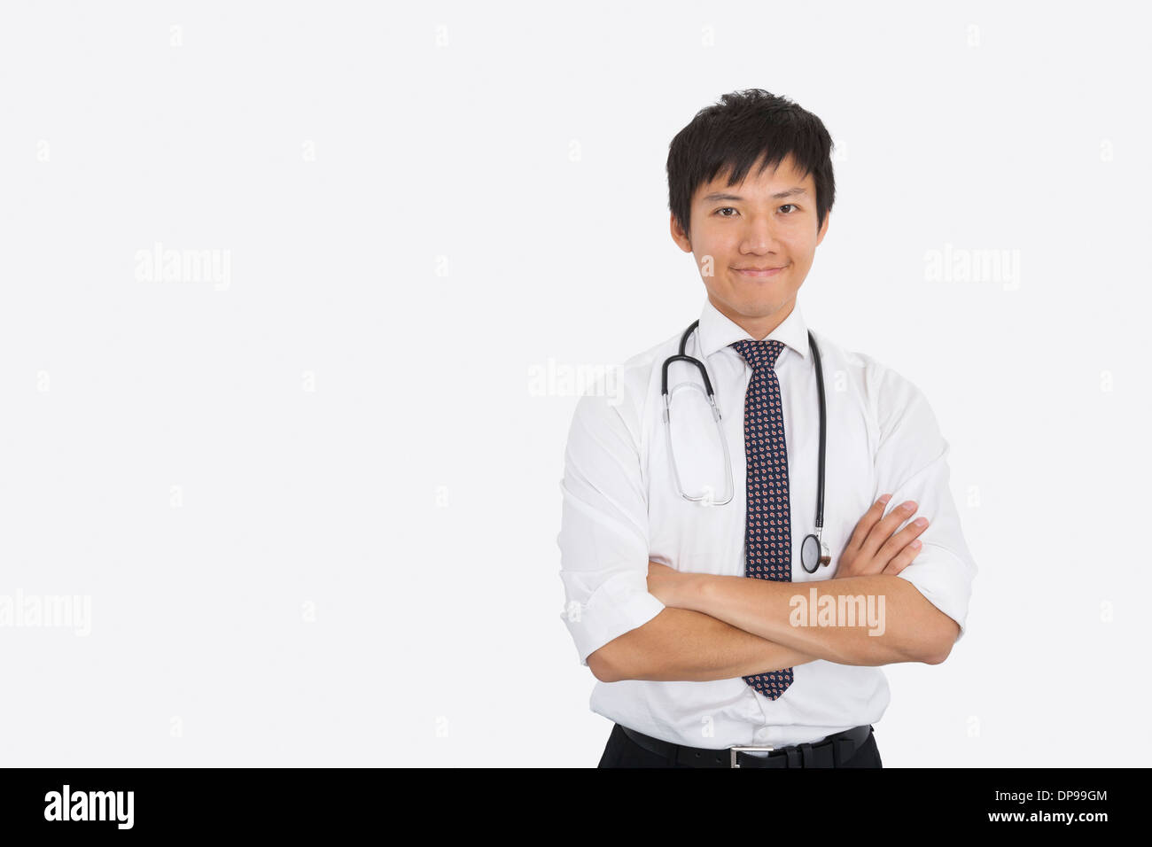 Portrait of Asian male doctor with arms crossed over white background ...