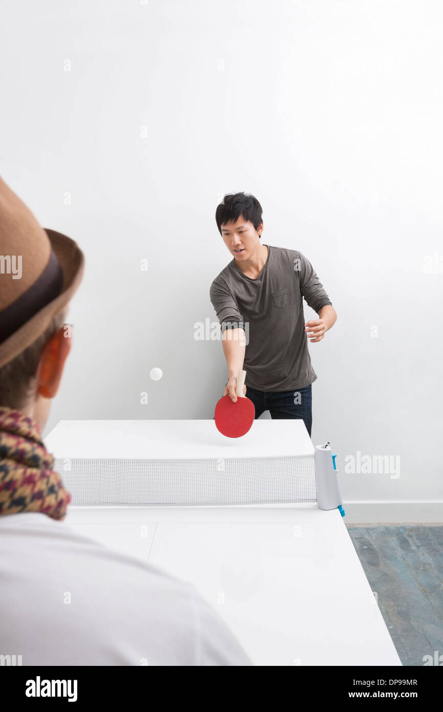 Mid adult man playing table tennis with friend Stock Photo - Alamy